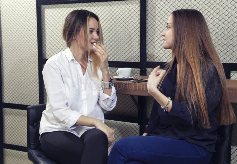 Two Young Girls Absorbedly Talking while Drinking Tea at the Counter in ...