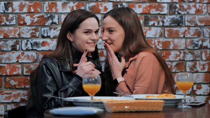 Two Young Girls Gossiping Sitting in a Cafe. Stock Photo - Image of ...