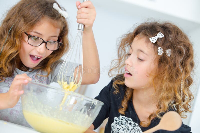 Two Young Girls Making on Cake on Their Own at Stock Photo - Image of ...