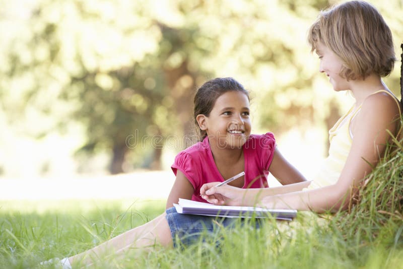Two Young Girls Sketching in Countryside Leaning Against Tree Stock ...