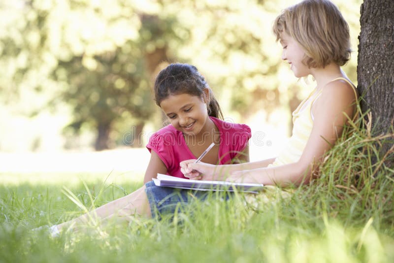 Two Young Girls Sketching in Countryside Leaning Against Tree Stock ...