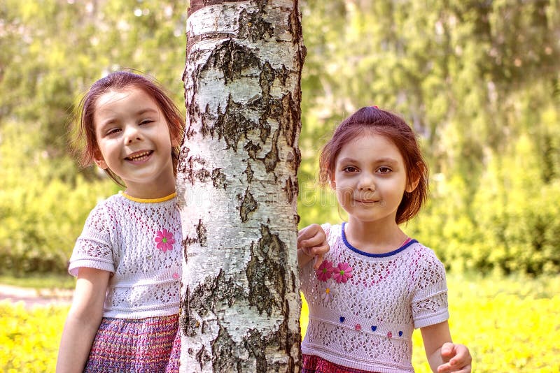 Two Young Girls Stands Near a Tree Stock Photo - Image of meadow ...