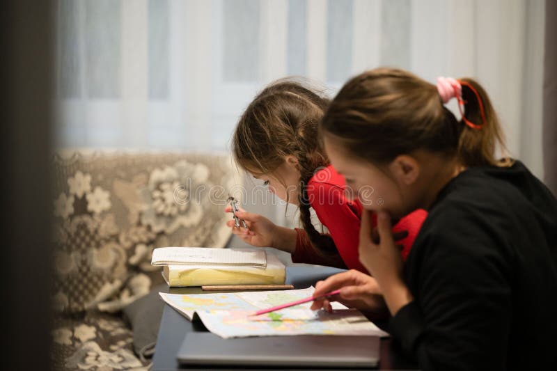 Two Young Girls Collaboratively Engaging in a Home-based Educational ...