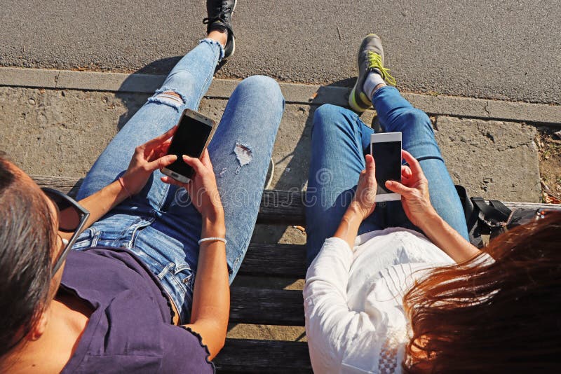 Two Young Girls Watching Mobile Phones Stock Photo - Image of caucasian ...