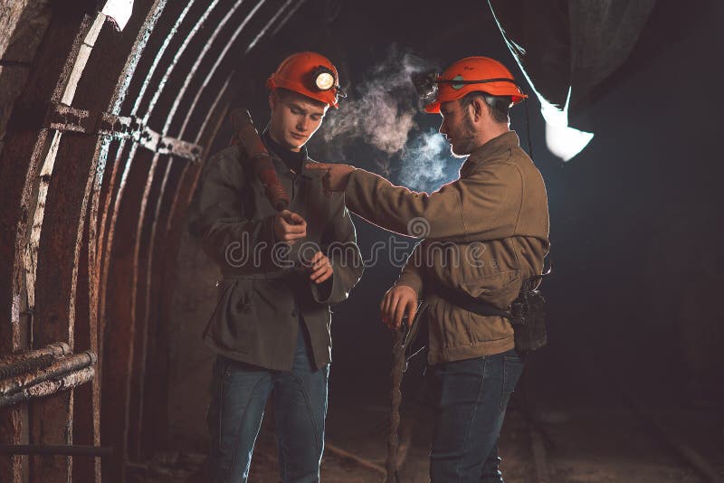 Two Young Guys in Special Clothes and Helmets Standing in the Mine ...