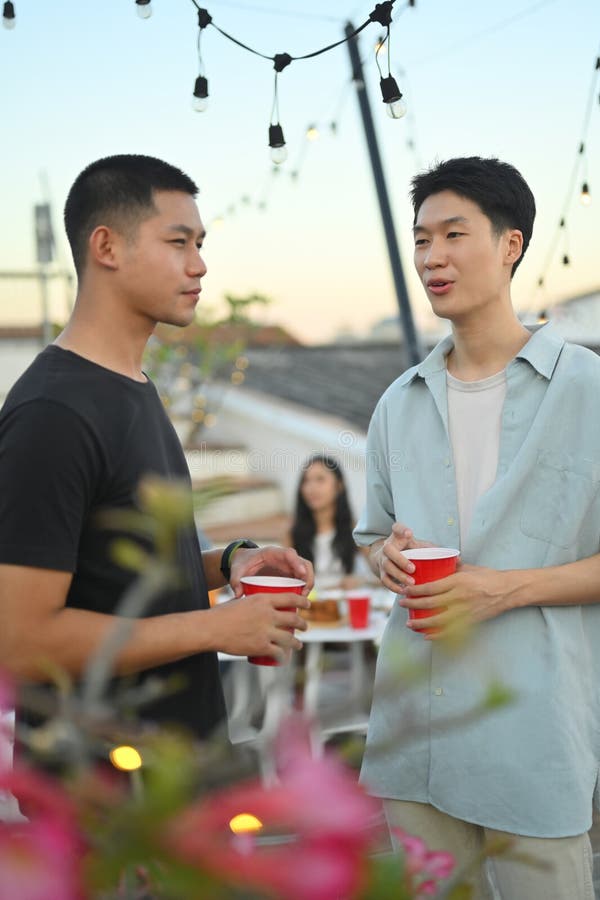 Two Young Handsome Men Having Drinks and Chatting at the Rooftop Party ...