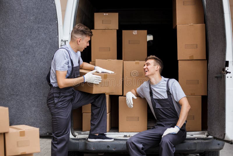 Two Young Handsome Movers Wearing Uniforms are Laughing while Unloading ...