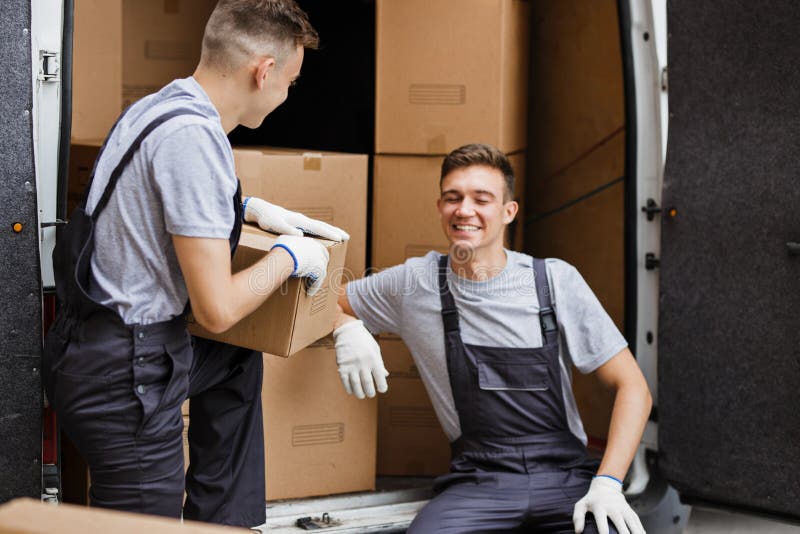 Two Young Handsome Movers Wearing Uniforms are Laughing while Unloading ...