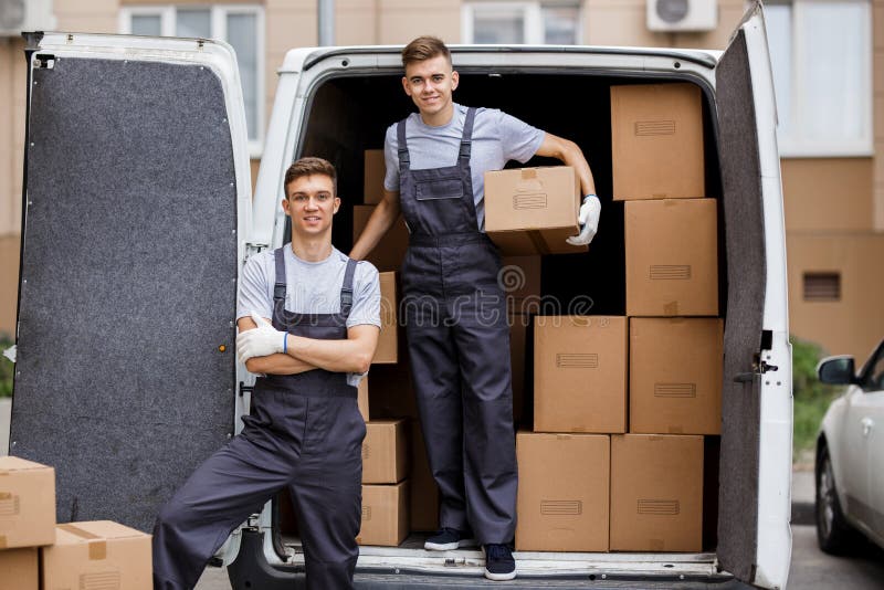 Two Young Handsome Smiling Movers Wearing Uniforms are Unloading the ...