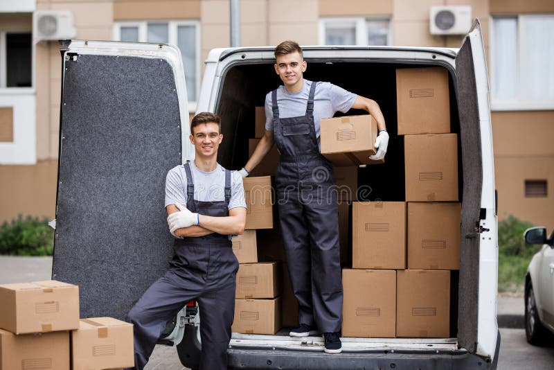 Two Young Handsome Smiling Movers Wearing Uniforms are Unloading the ...