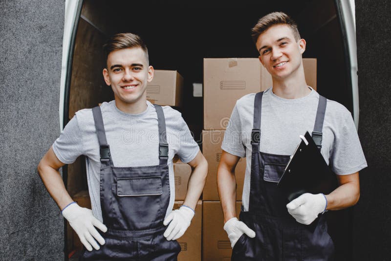 Two Young Handsome Smiling Workers Wearing Uniforms are Standing in ...