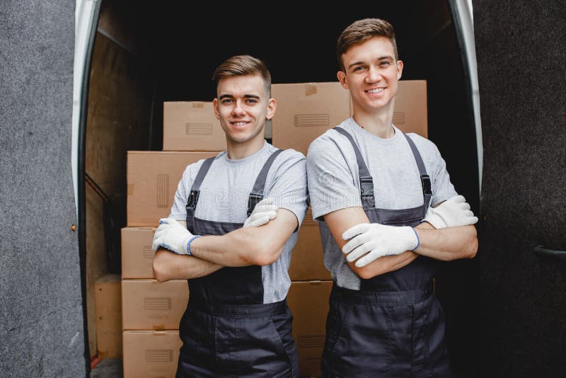 Two Young Handsome Smiling Workers Wearing Uniforms are Standing in ...