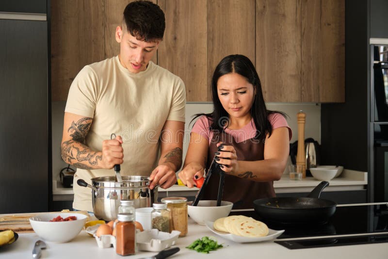 Two Young Latin People Preparing Arepas at Kitchen. Stock Photo - Image ...