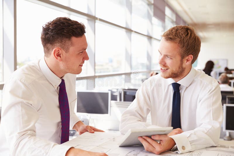 Two Young Male Architects in Discussion at an Office Desk Stock Photo ...