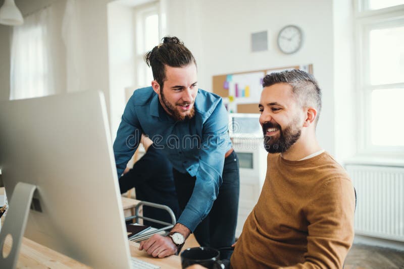 Two Young Male Businesspeople with Computer Talking in a Modern Office ...