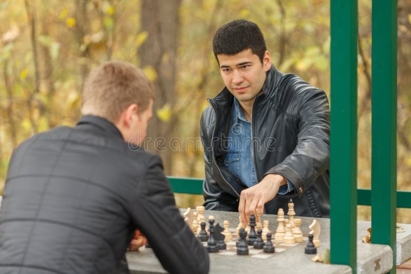 Two Young Men in Black Jackets Playing Chess Stock Photo - Image of ...