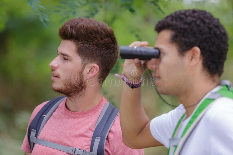 Two Young Men in Countryside One Looking through Binoculars Stock Photo ...