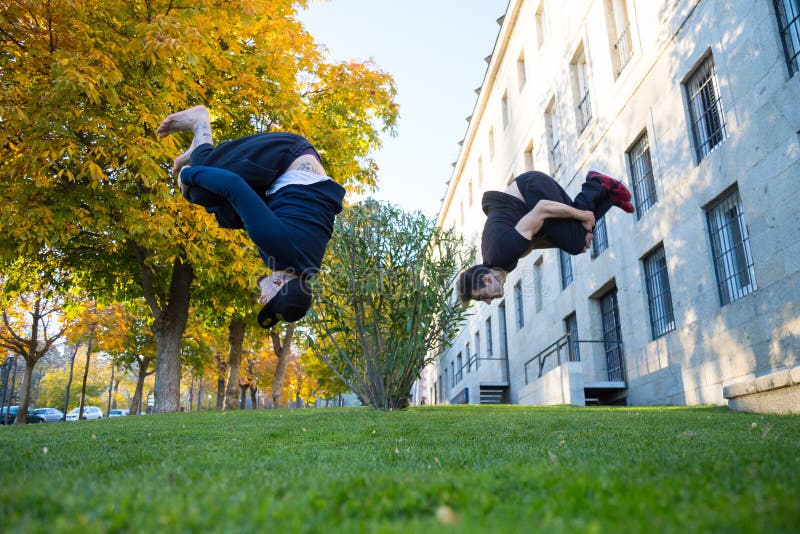 Two Young Men Doing a Side Flip Stock Photo - Image of ground ...