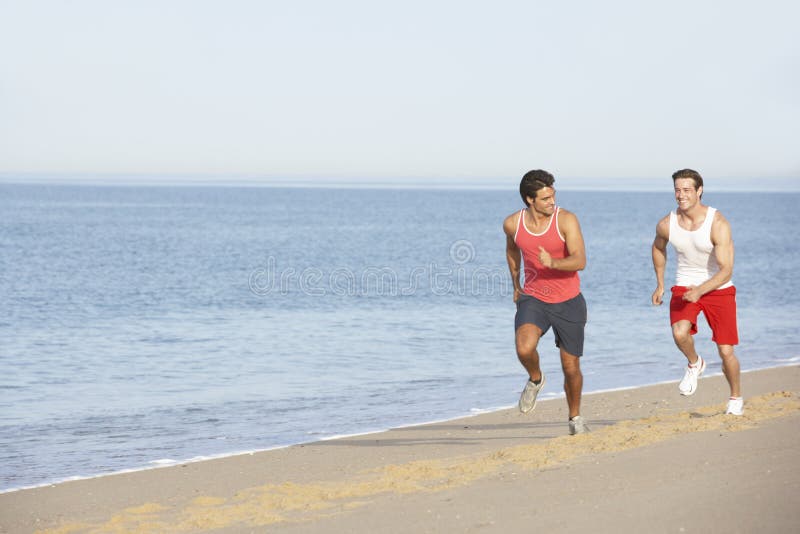 Two Young Men Jogging Along Beach Stock Image - Image of jogging ...