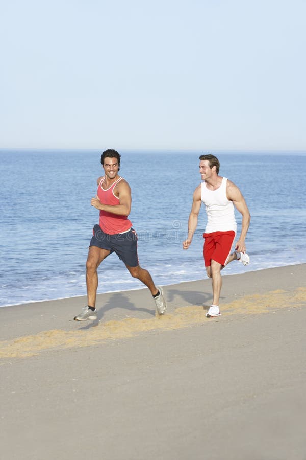 Two Young Men Jogging Along Beach Stock Photo - Image of male, outdoors ...
