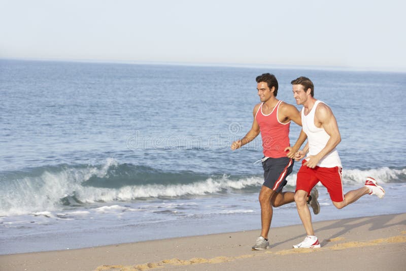 Two Young Men Jogging Along Beach Stock Photo - Image of racing ...