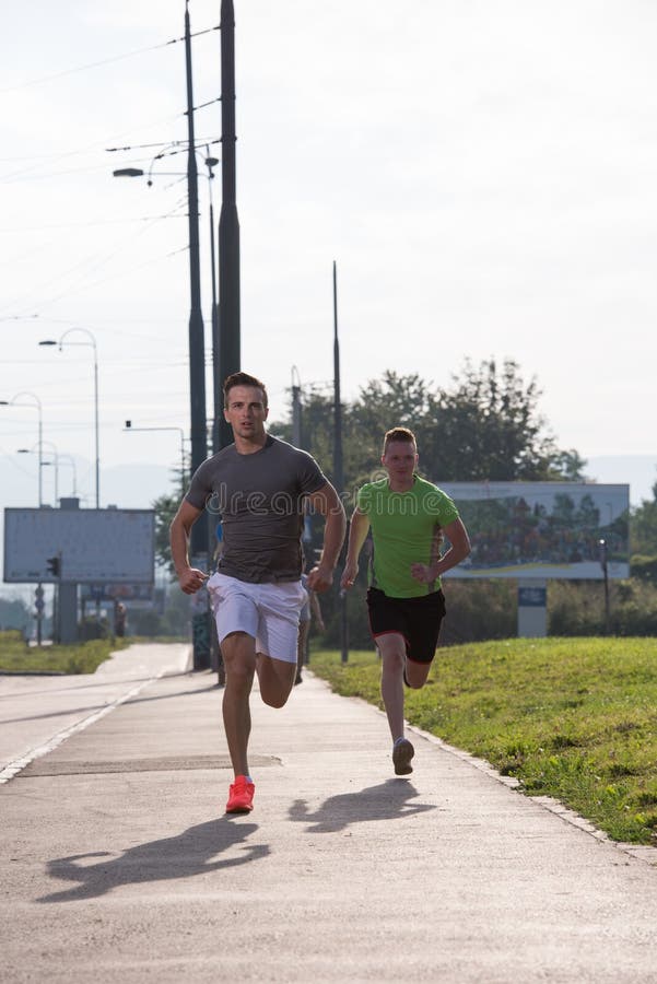 Two Young Men Jogging through the City Stock Image - Image of male ...