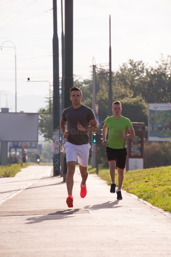 Two Young Men Jogging through the City Stock Image - Image of person ...
