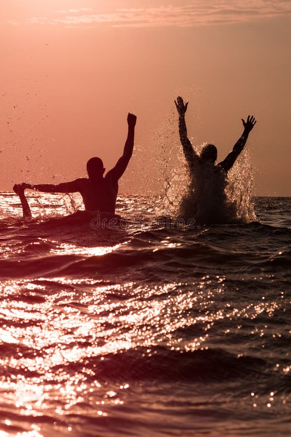 Two Young Men Splashing Water in the Sea Stock Image - Image of light ...