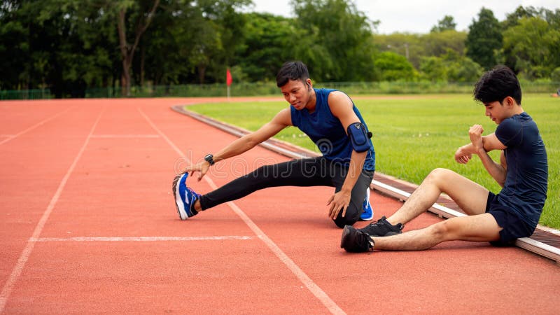 Two Young Men Stretching and Cooling Down on Outdoor Running Track ...