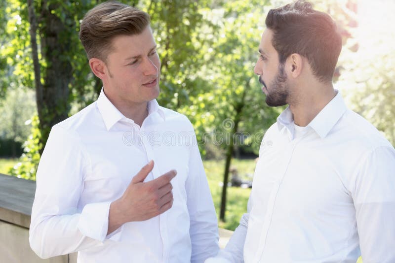 Two Young Men Talking To Each Other in Park Stock Image - Image of ...