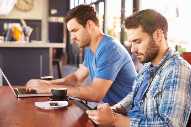 Two Young Men Working on Computers at a Coffee Shop Stock Image - Image ...