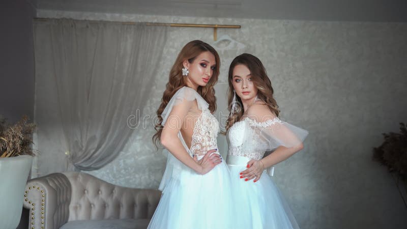 Two Young Models Posing in Front of the Photographer in a Wedding Dress ...