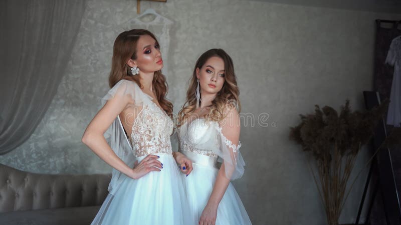 Two Young Models Posing in Front of the Photographer in a Wedding Dress ...