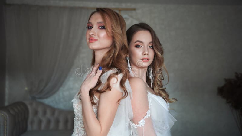 Two Young Models Posing in Front of the Photographer in a Wedding Dress ...