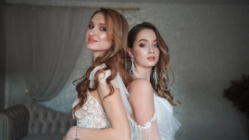 Two Young Models Posing in Front of the Photographer in a Wedding Dress ...
