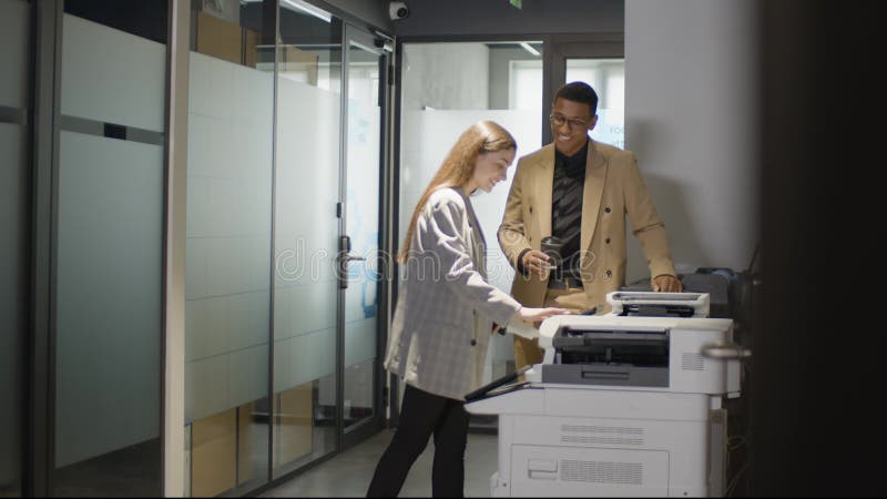 Two Young Multiethnic Colleagues is Copying Documents at Office ...