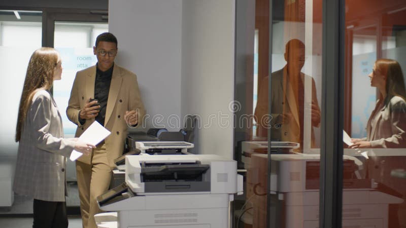 Two Young Multiethnic Colleagues is Copying Documents at Office ...