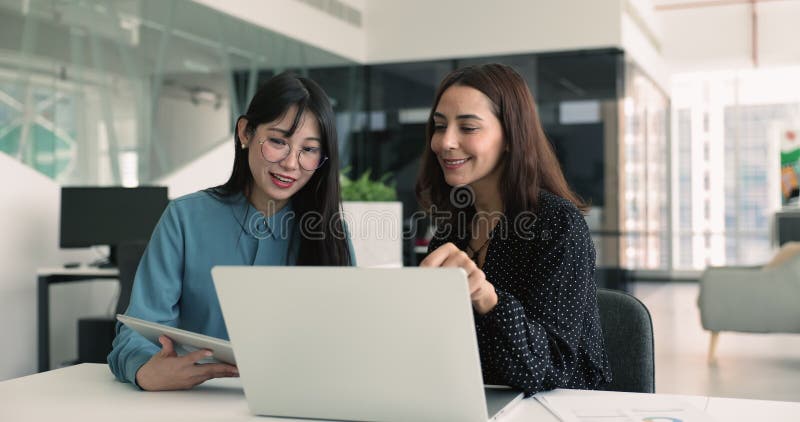 Two Young Multiracial Women Collaborating on on-line Project Stock ...