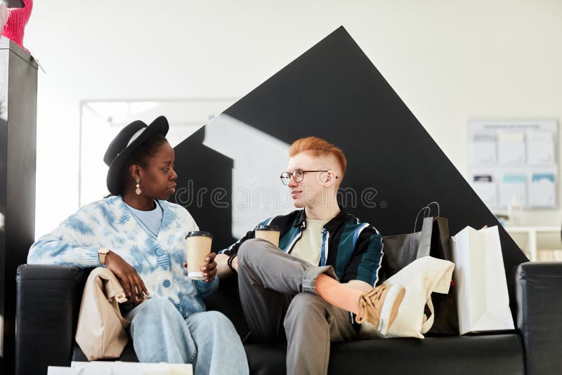 Two Young People Chatting in Library Lounge and Drinking Coffee Stock ...