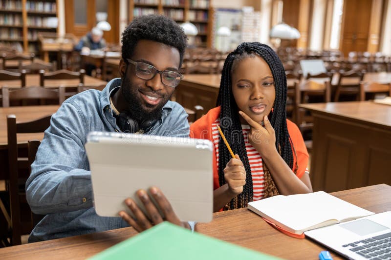 Two Young People Sitting in the Library and Working on the Project ...