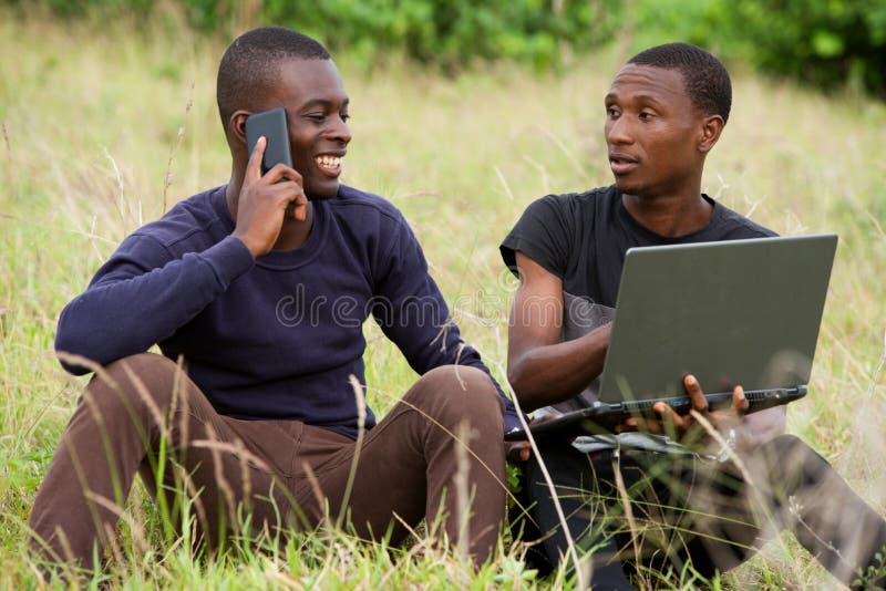 Two Young People Sitting at the Park Talking in Front of a Laptop Stock ...