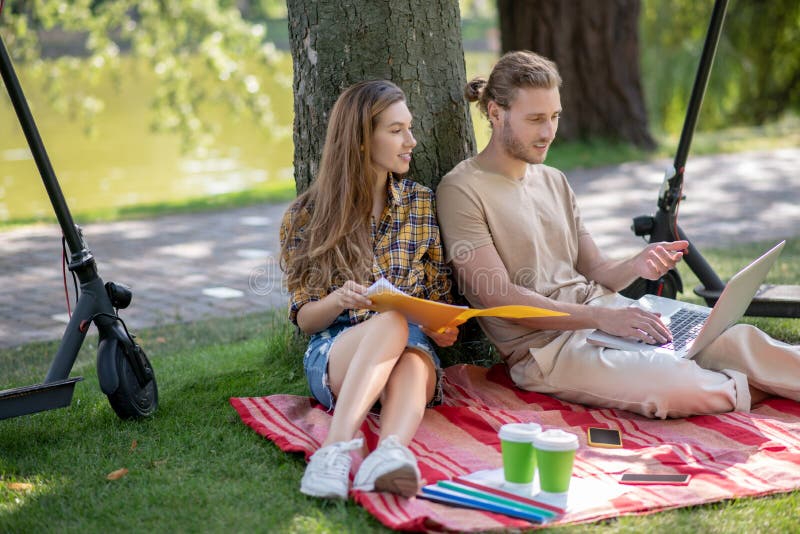 Two Young People Sitting Under the Tree and Studying Stock Photo ...