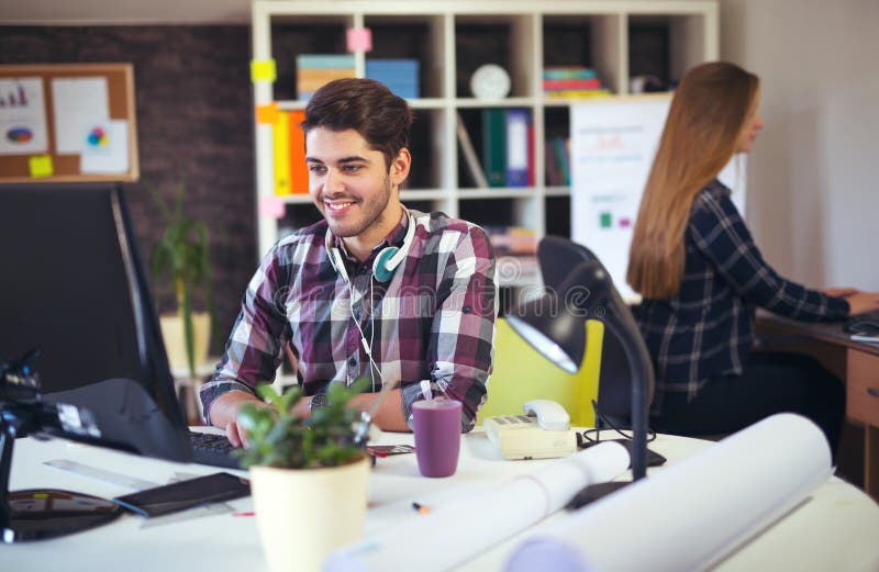 Two Young People Working on Their Computers, Focus on the Man Stock ...