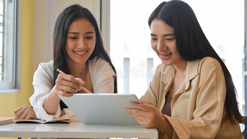 Two Young Pretty Female Students Doing Assignment with Digital Tablet ...