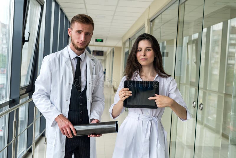 Two Young Trainee Doctors Pose in the Corridor of a Modern Hospital ...