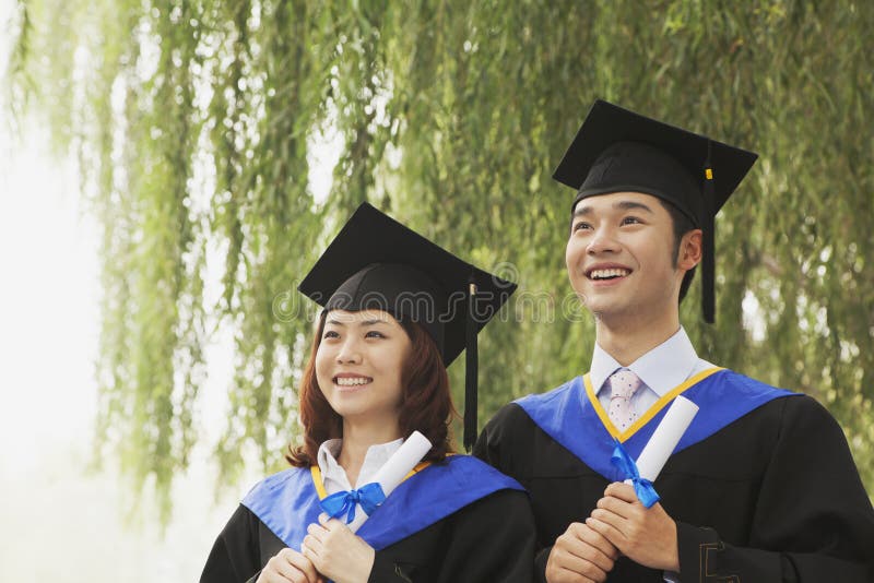 Two Young University Graduates Looking at the Camera, Man in Front ...