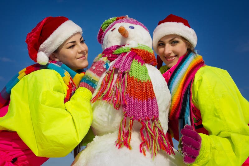 Two Young Woman with a Snowman Stock Photo - Image of white, snow: 28041778