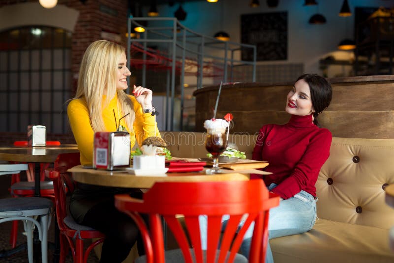 Two Young Women Chatting in a Cafe. Stock Image - Image of group, food ...