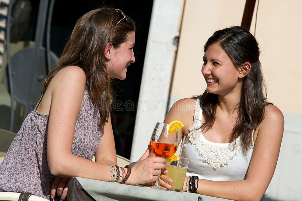 Two Young Women Cheering with Cold Drinks Stock Photo - Image of face ...