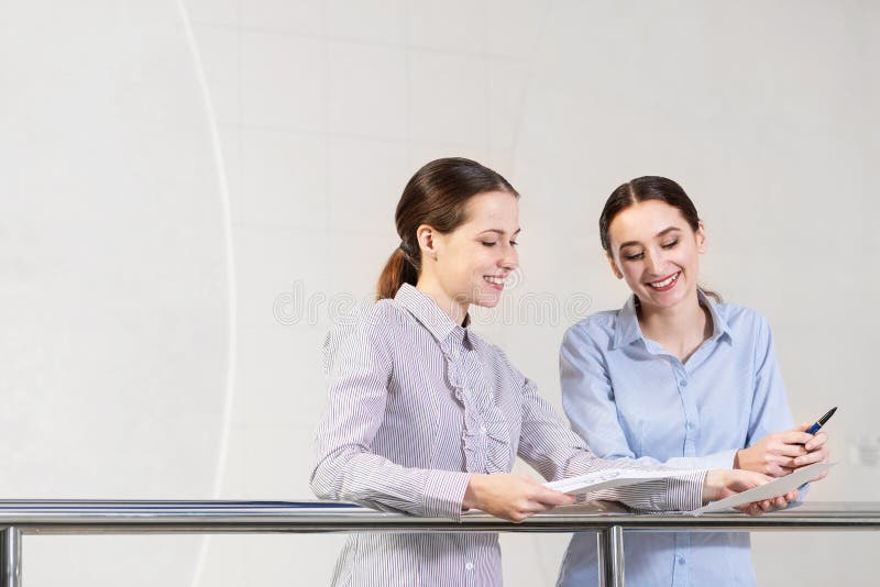 Two Young Women Discuss Documents Stock Photo - Image of corporate ...